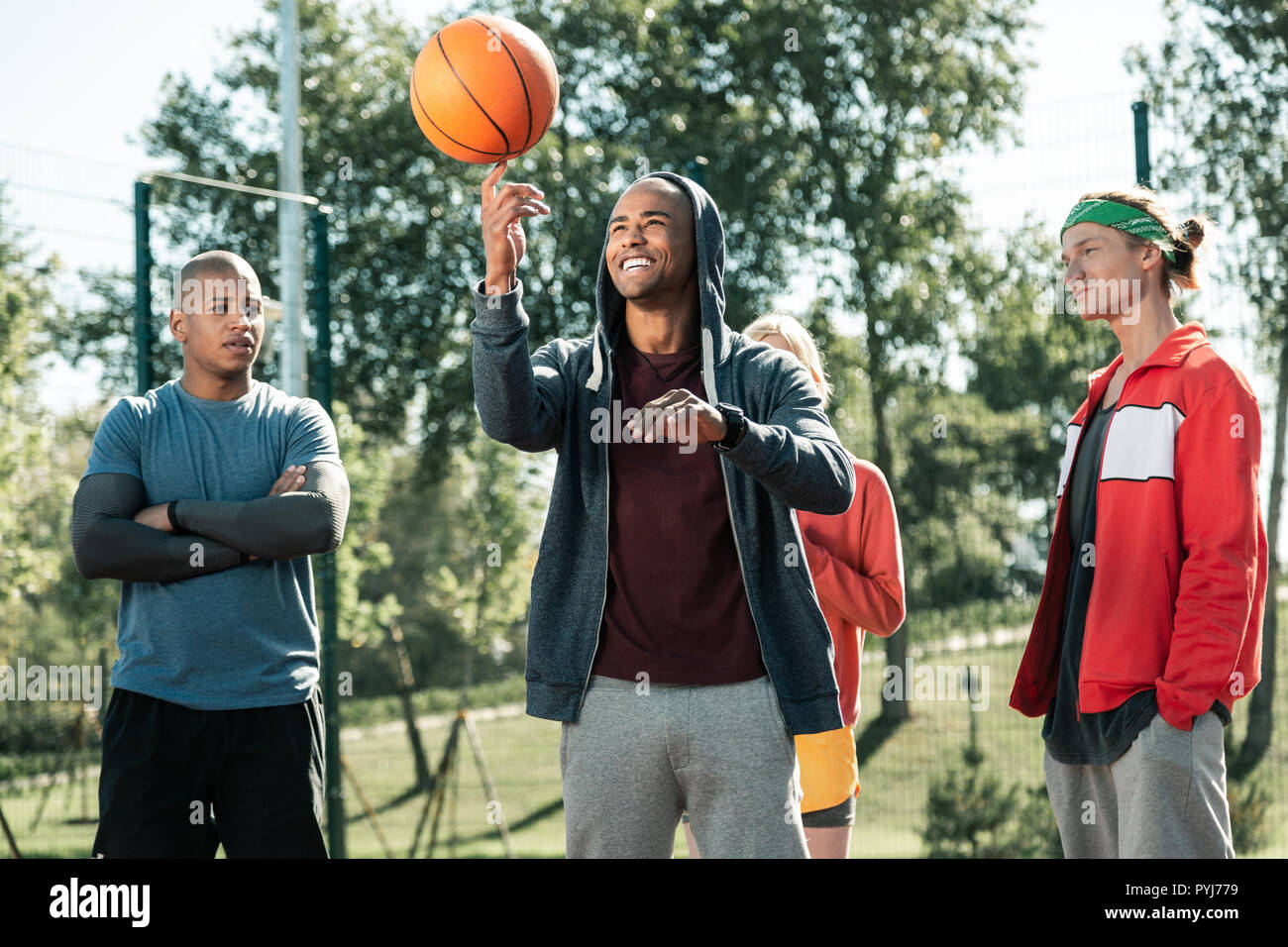 Positive cheerful man showing how to rotate the ball Stock Photo - Alamy