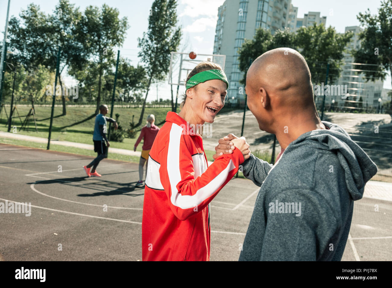 Joyful positive young men greeting each other Stock Photo - Alamy