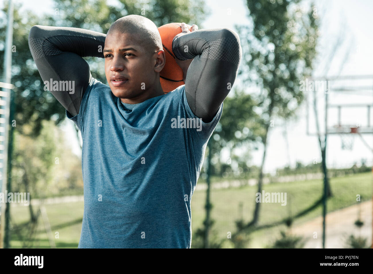Nice handsome man holding a ball above him Stock Photo - Alamy