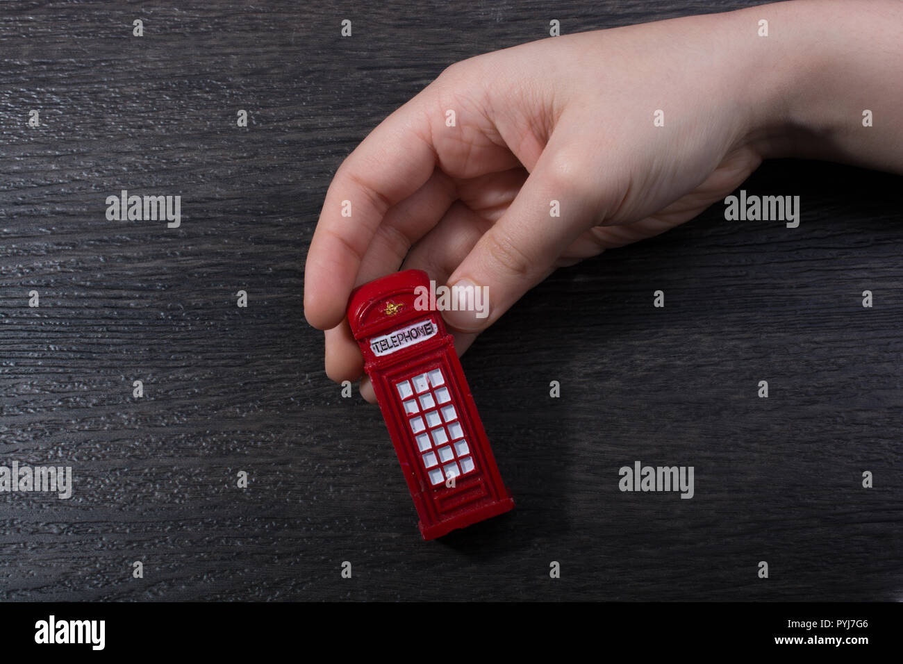 Hand holding a phone booth on a dark background Stock Photo - Alamy