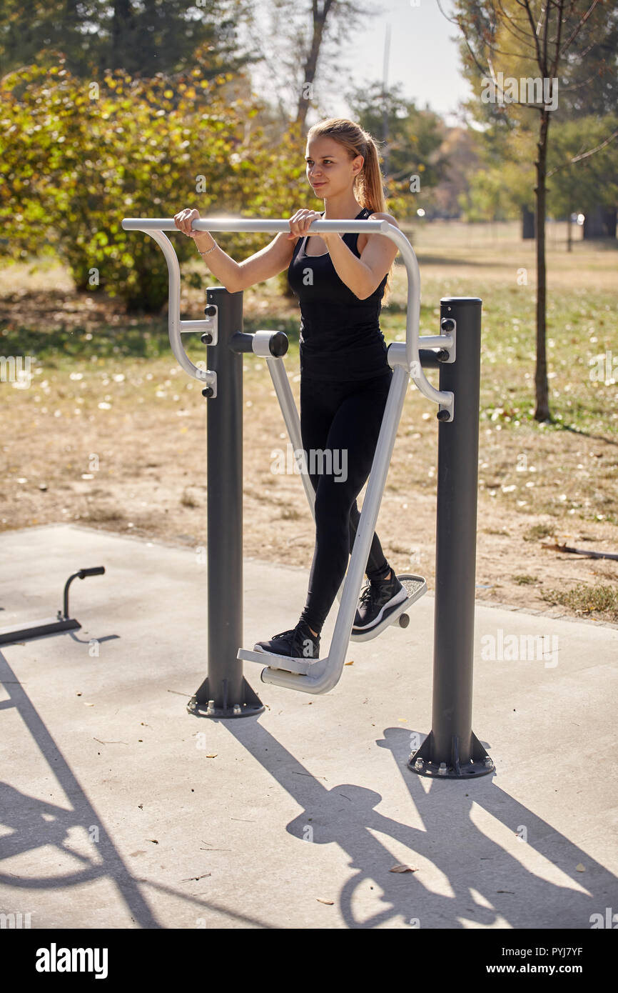 one young woman, outdoors public gym in park, leg exercise Stock Photo ...