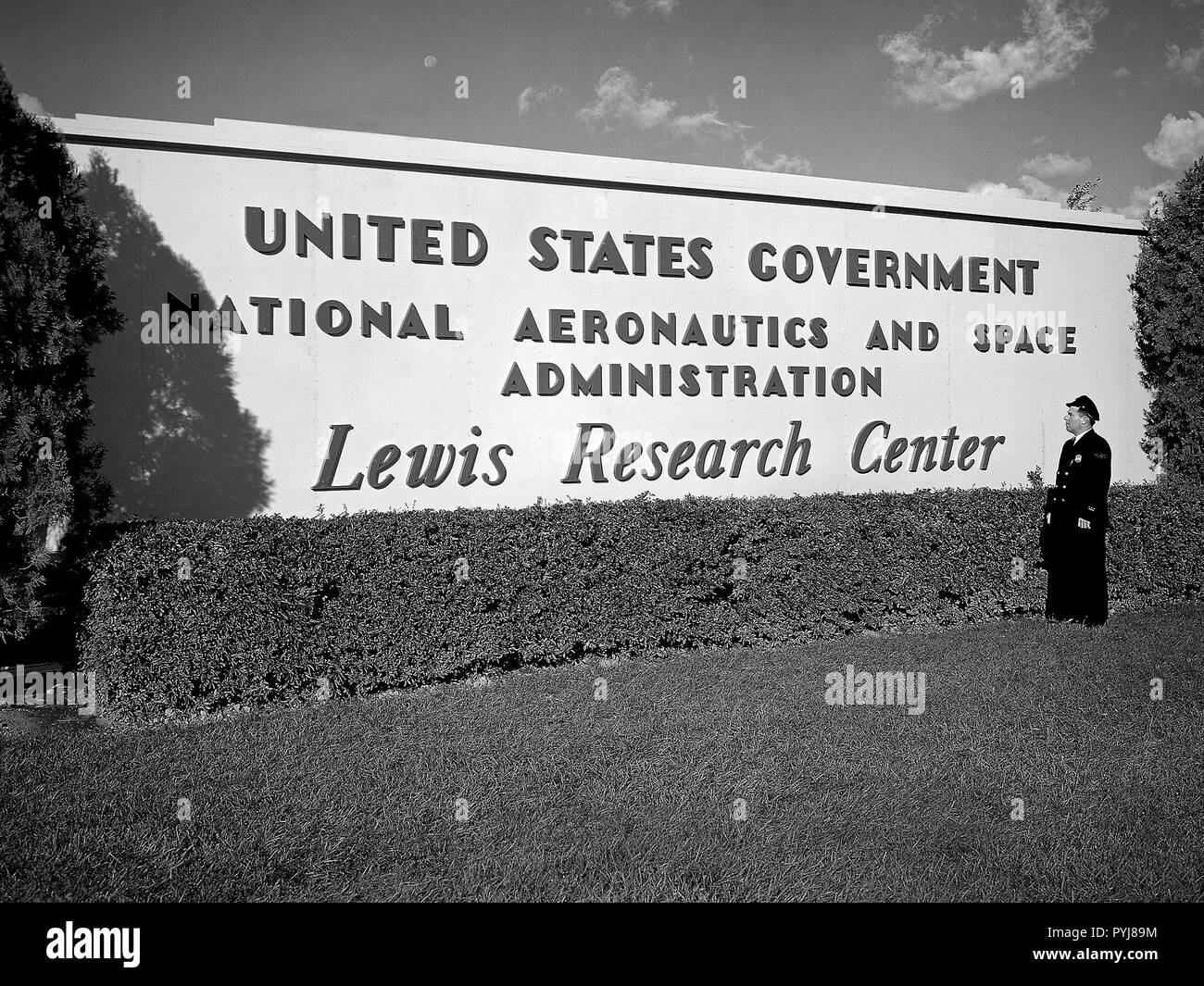 A security guard examines the new sign near the entrance to the Lewis ...