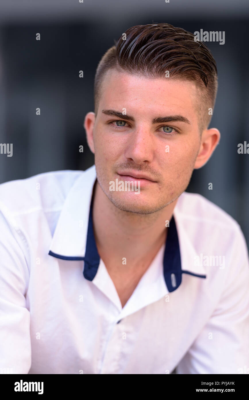 Face of young handsome man outside modern house Stock Photo - Alamy