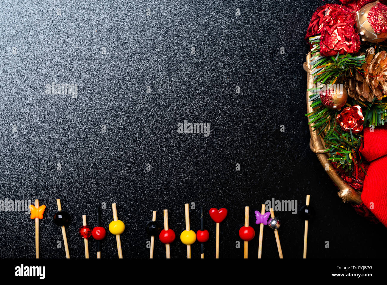 Christmas wreath with color skewers isolated on black, holly, holiday ...