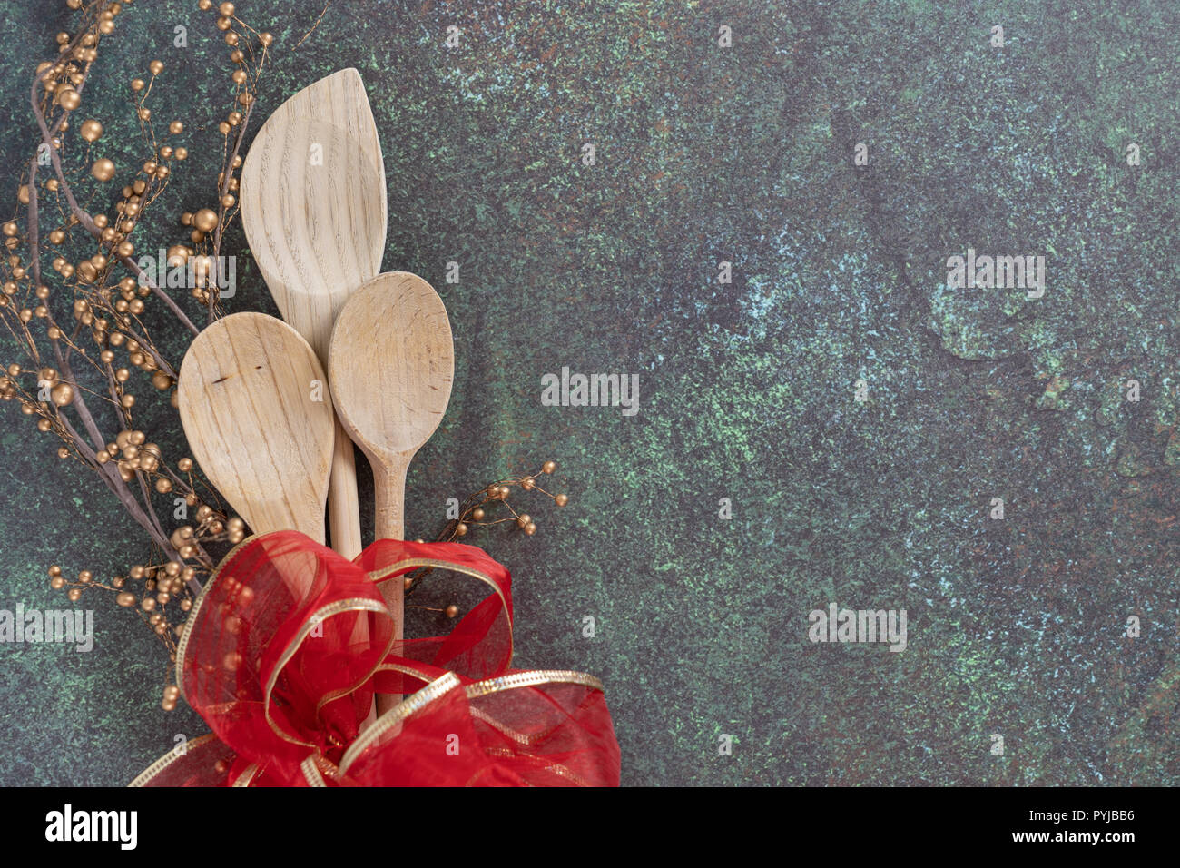 red ribbon with wooden spoons on blue green counter top from above for ...