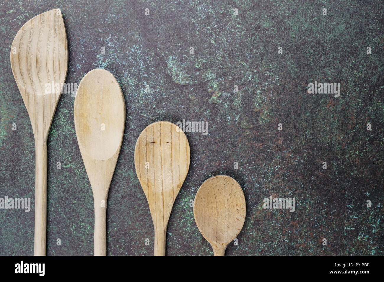 left corner wooden spoon border on blue green patterned counter top ...