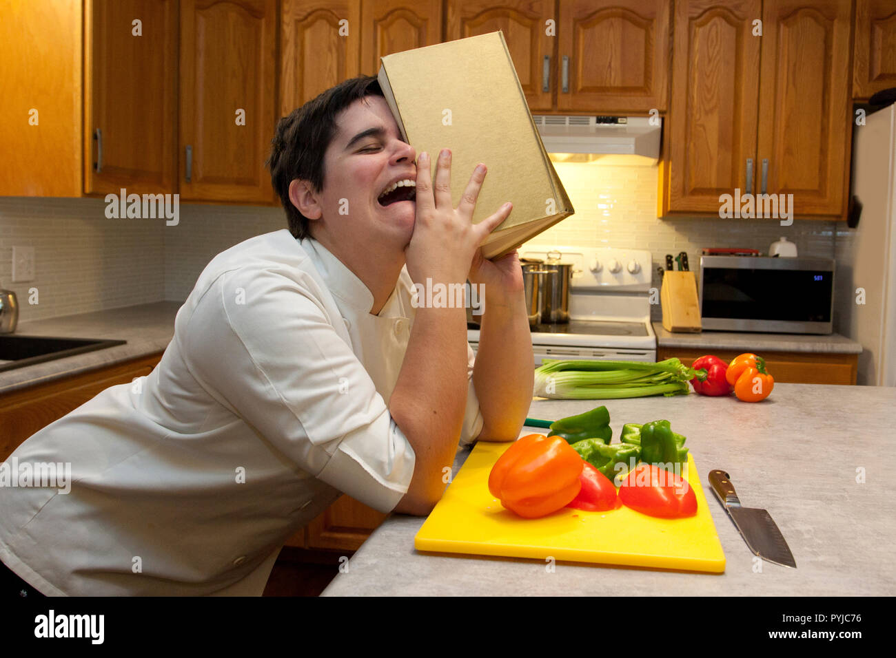 Person crying in the kitchen, sobbing into their cookbook with ...