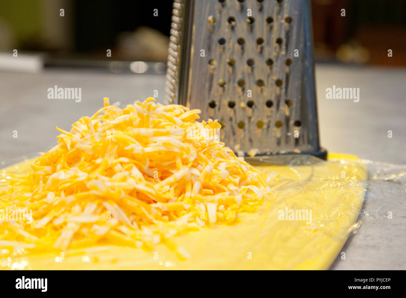 Pile of Shredded cheese beside a metal grater in the kitchen Stock ...