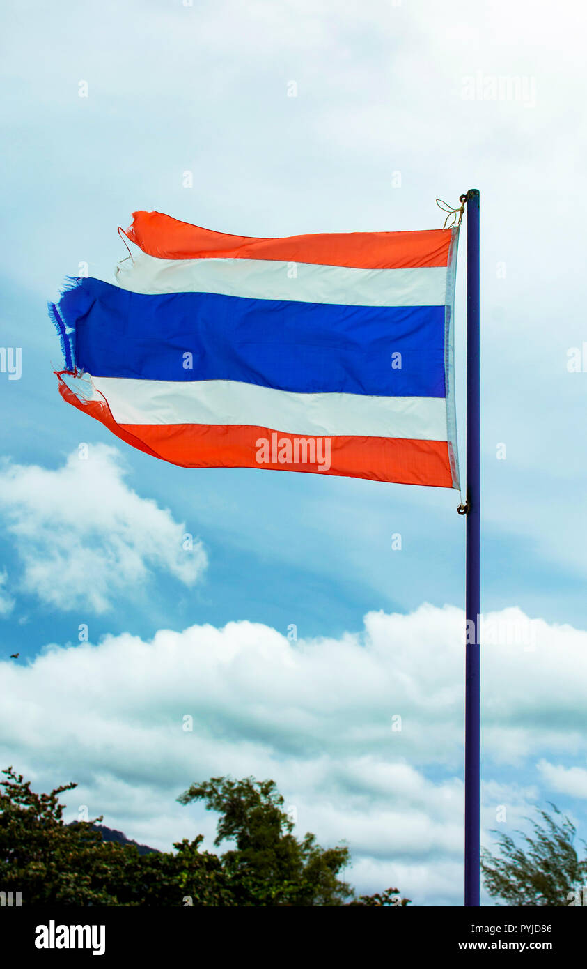 Wavy old flag of the Kingdom of Thailand against blue sky Stock Photo ...