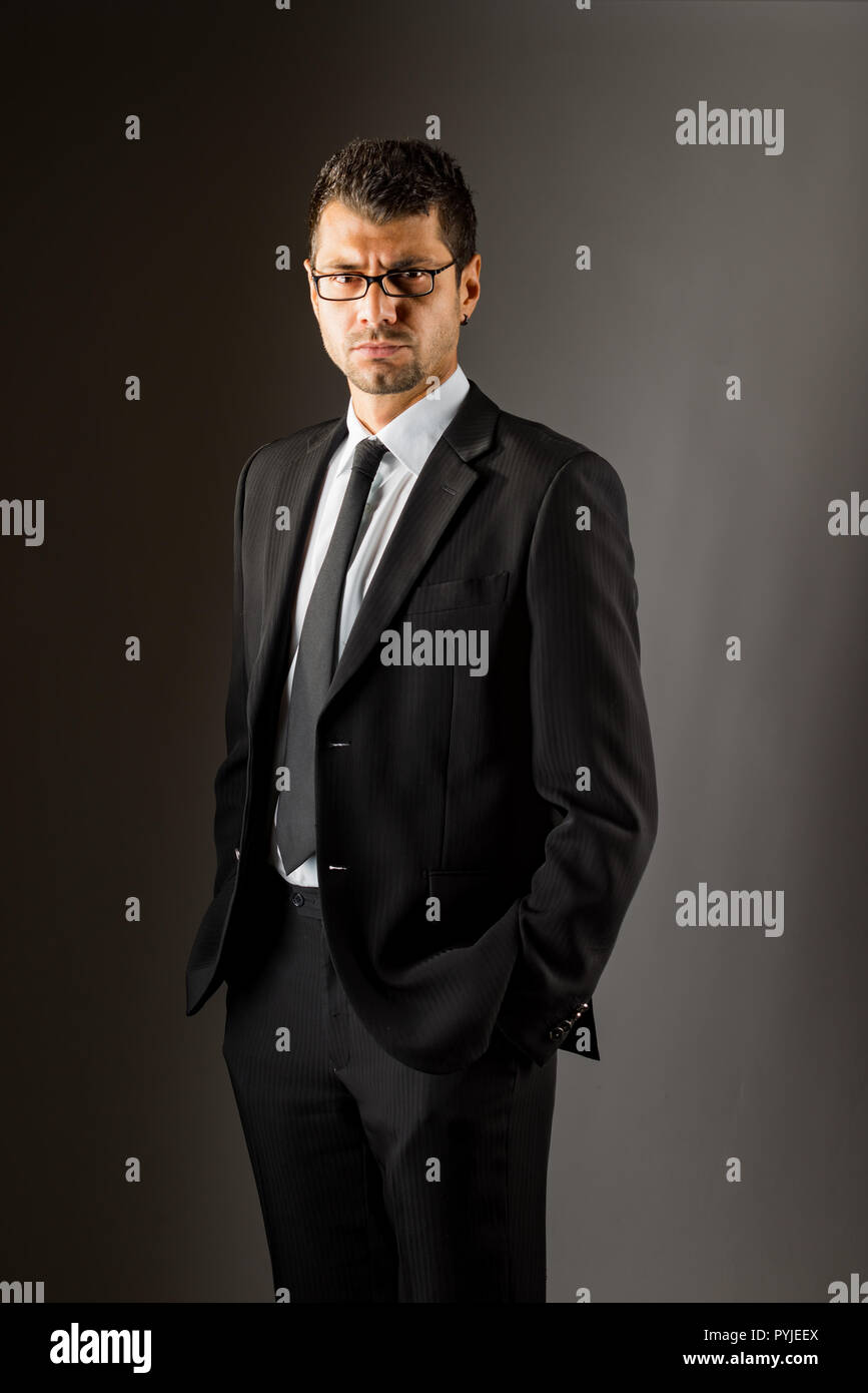 A serious man in a black suit. dark background Stock Photo - Alamy