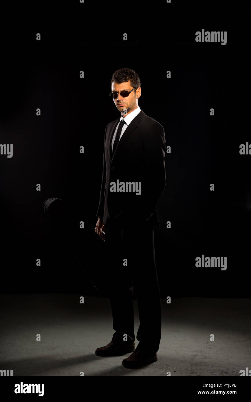 A serious man in a black suit. dark background Stock Photo - Alamy