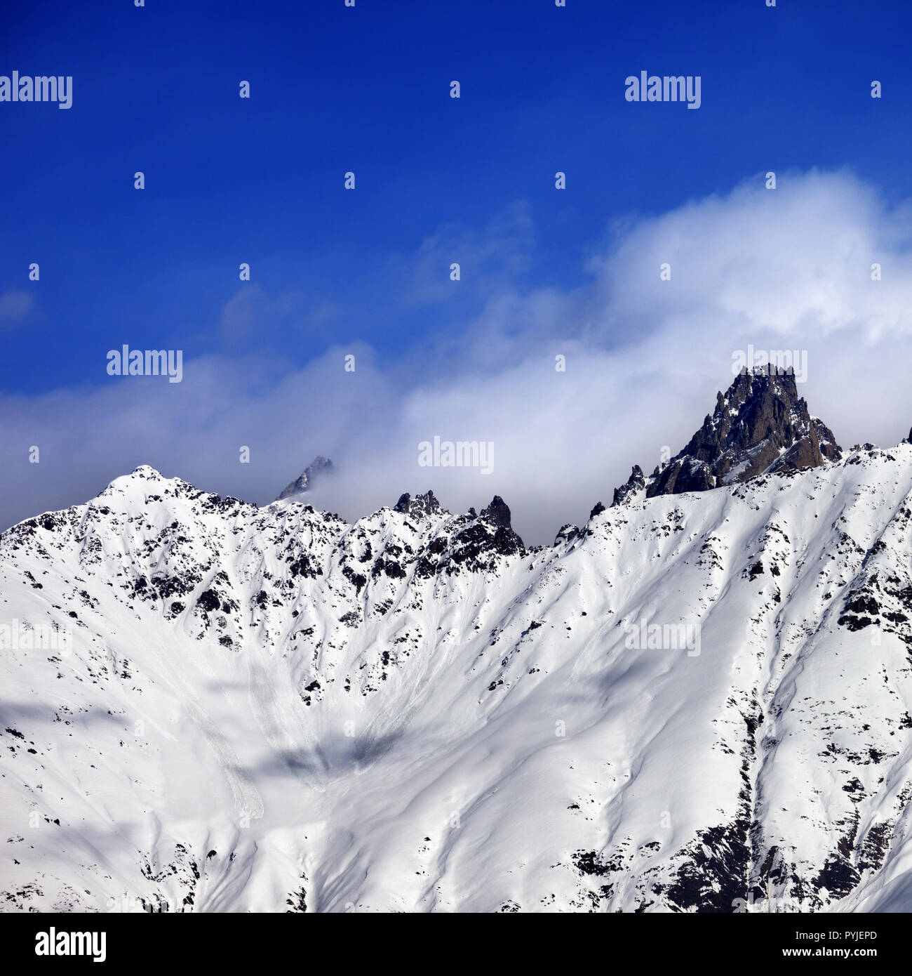 Snow avalanches mountainside in clouds. View from ski lift on Hatsvali ...