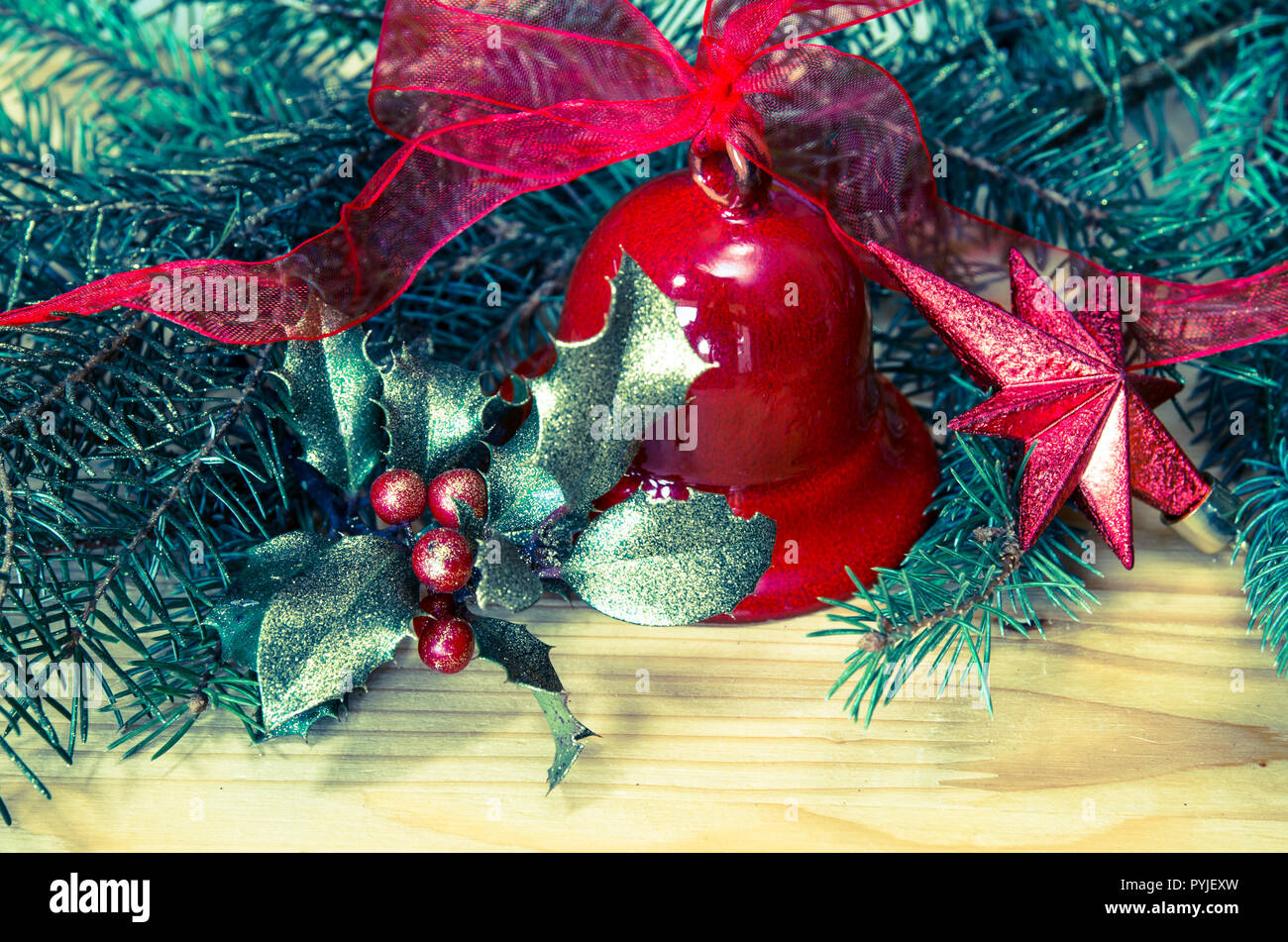 Christmas decoration with red jingle bell, holly and green needle ...