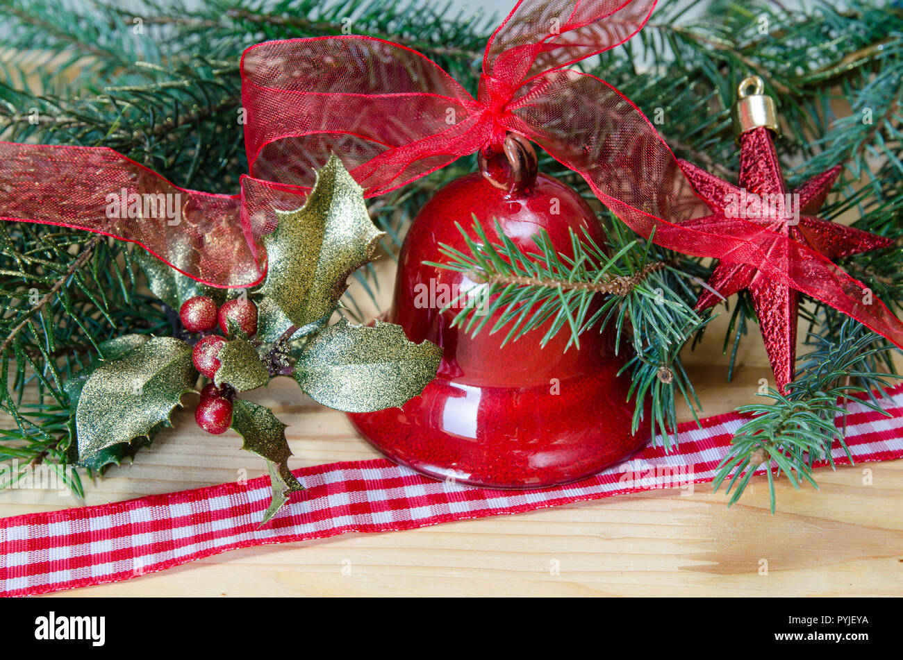 Christmas decoration with red jingle bell, holly and green needle ...