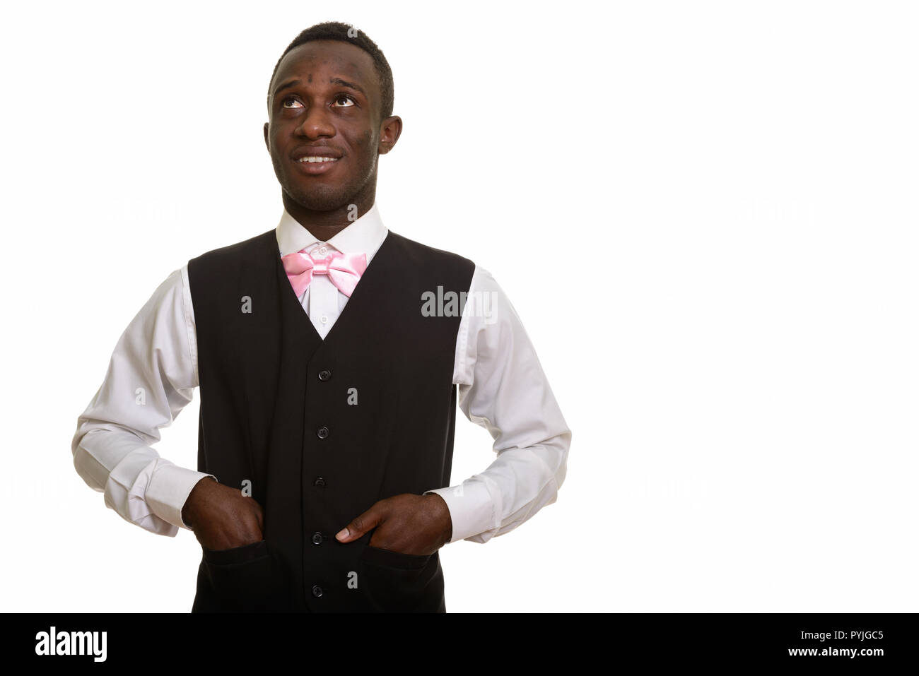 Young happy African waiter smiling and thinking Stock Photo - Alamy