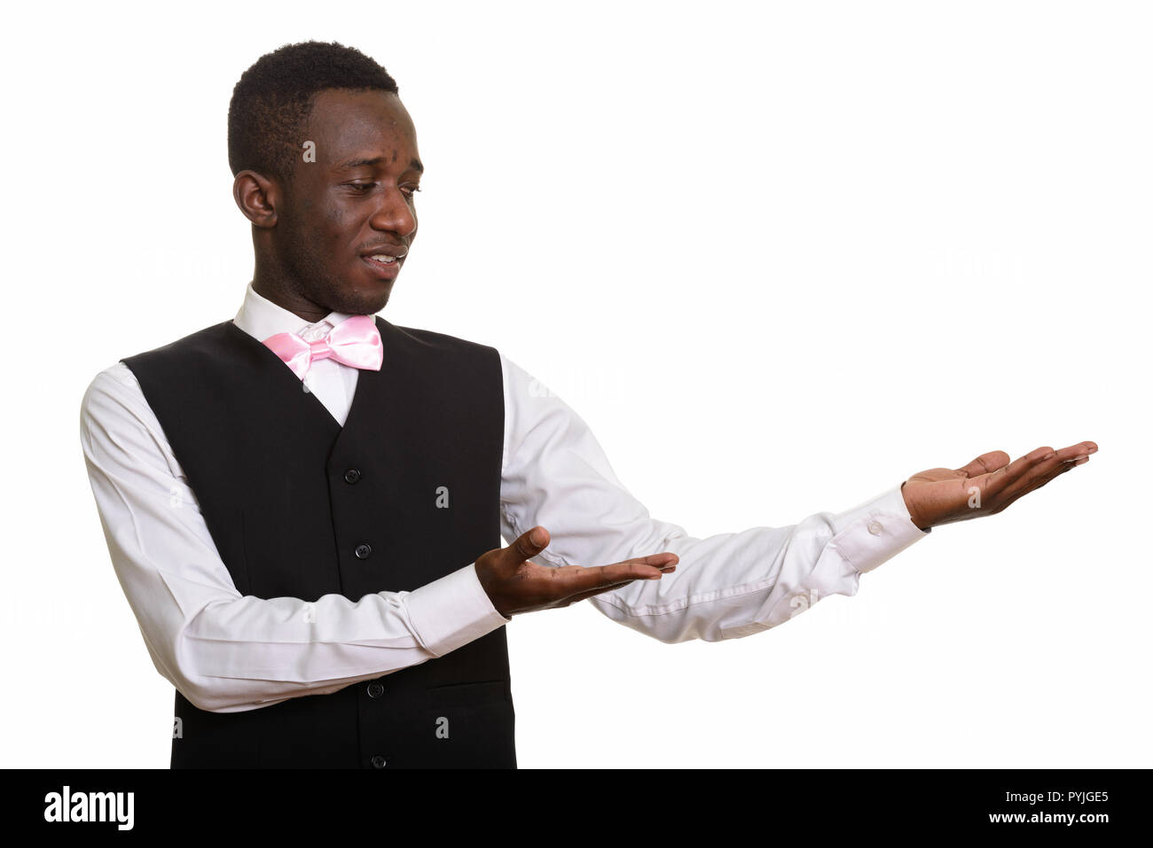 Young happy African waiter smiling and showing something Stock Photo ...