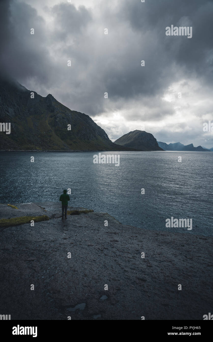 Lonely man standing in front of the atlantic ocean and looking at the ...