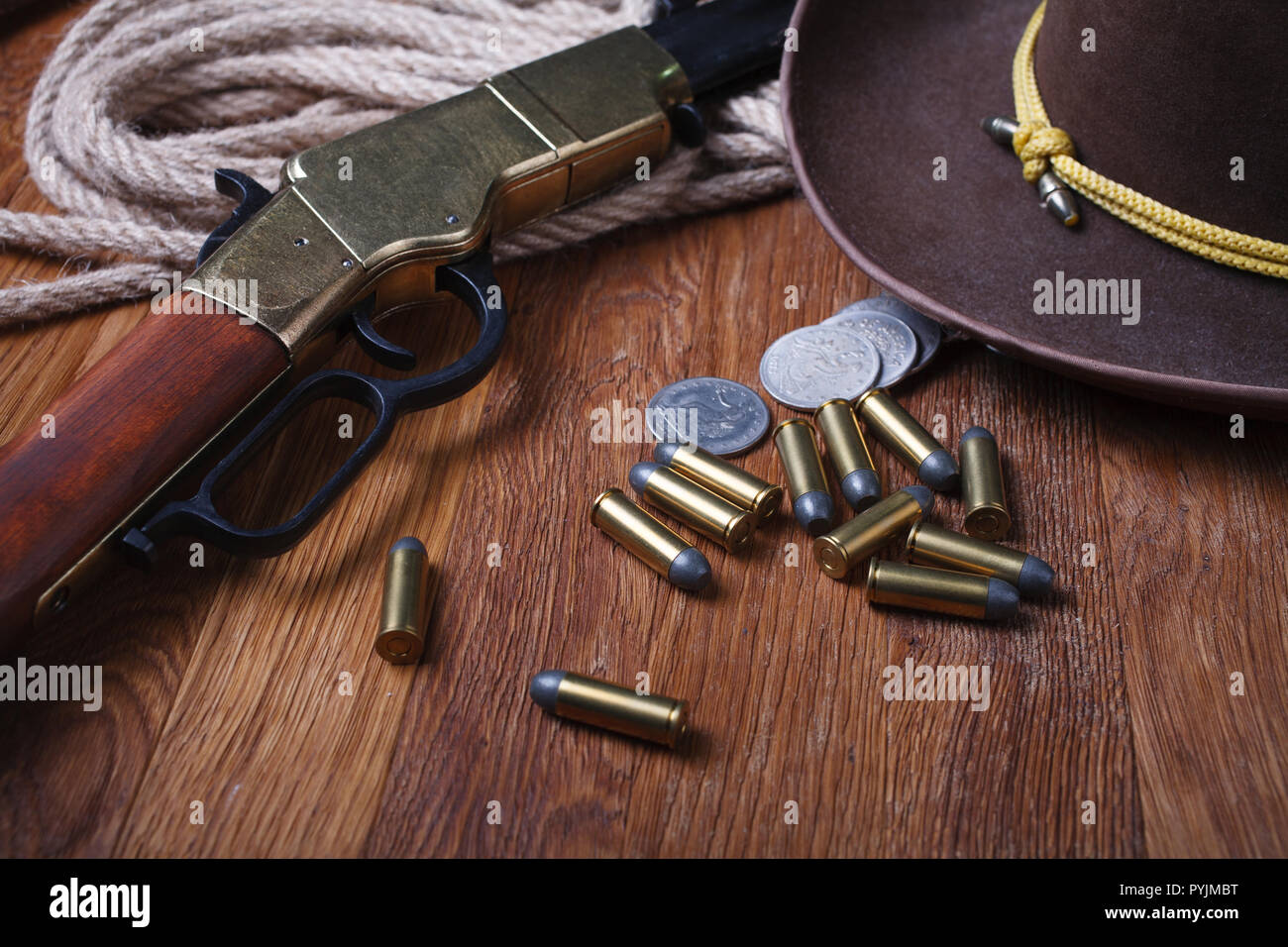 Wild west rifle, ammunition and silver dollars on wooden table Stock ...