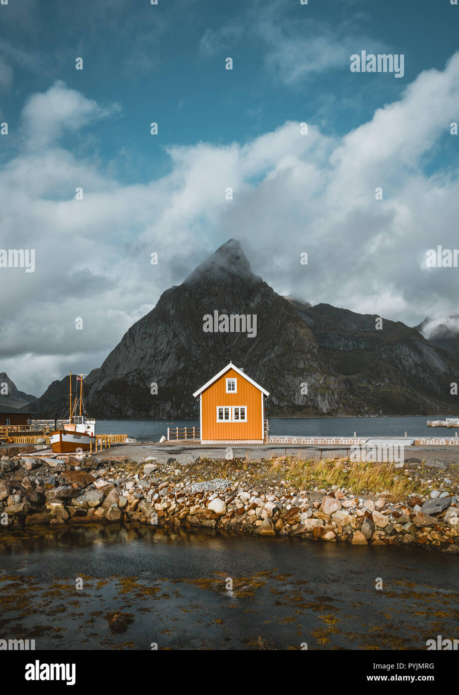 Yellow rorbu houses of Sakrisoy fishing village on a cloudy day with ...