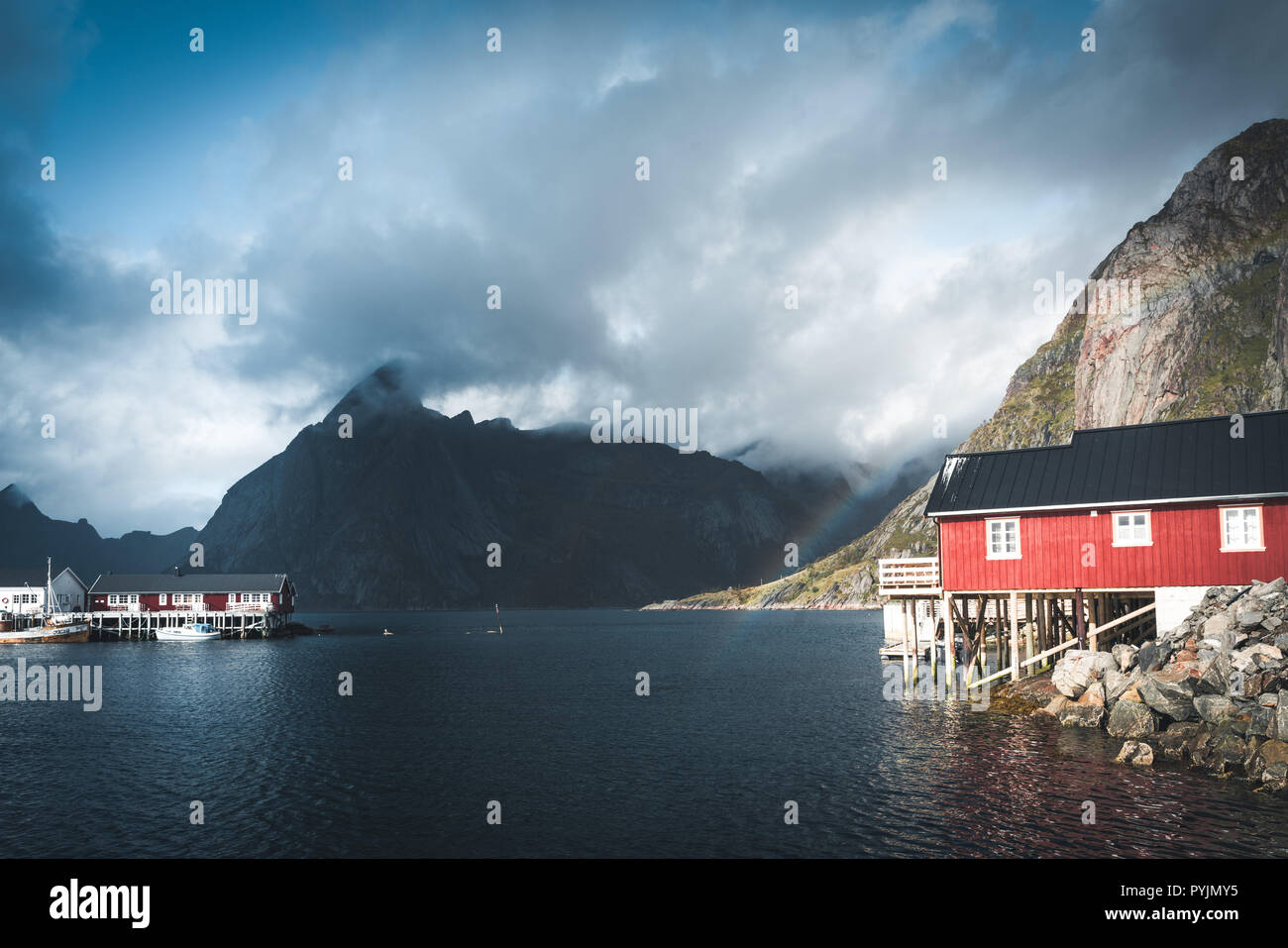 Rainbow ofer red houses rorbuer of Reine in Lofoten, Norway with red ...