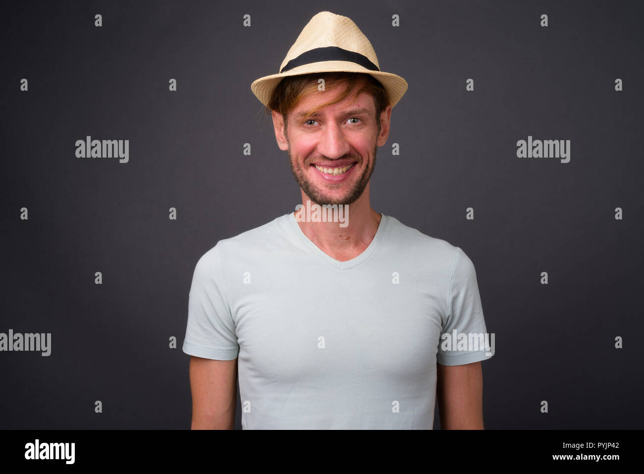 Studio shot of blond bearded tourist man against gray background Stock ...