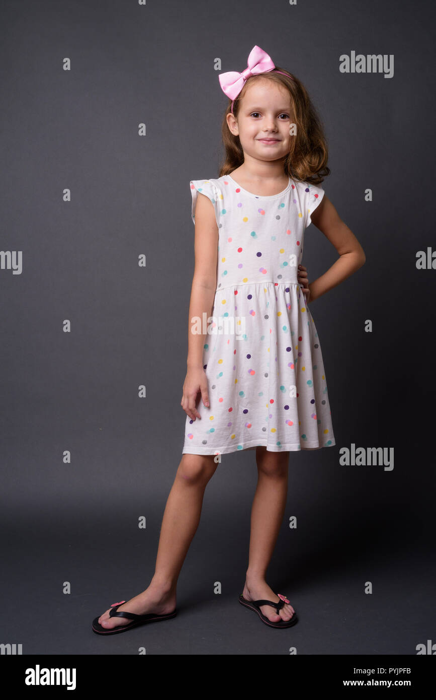 Cute young girl with blond hair against gray background Stock Photo - Alamy