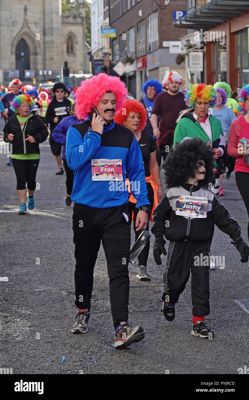 Liverpool, UK. 28th October 2018. Runners in colouful curly wigs take ...