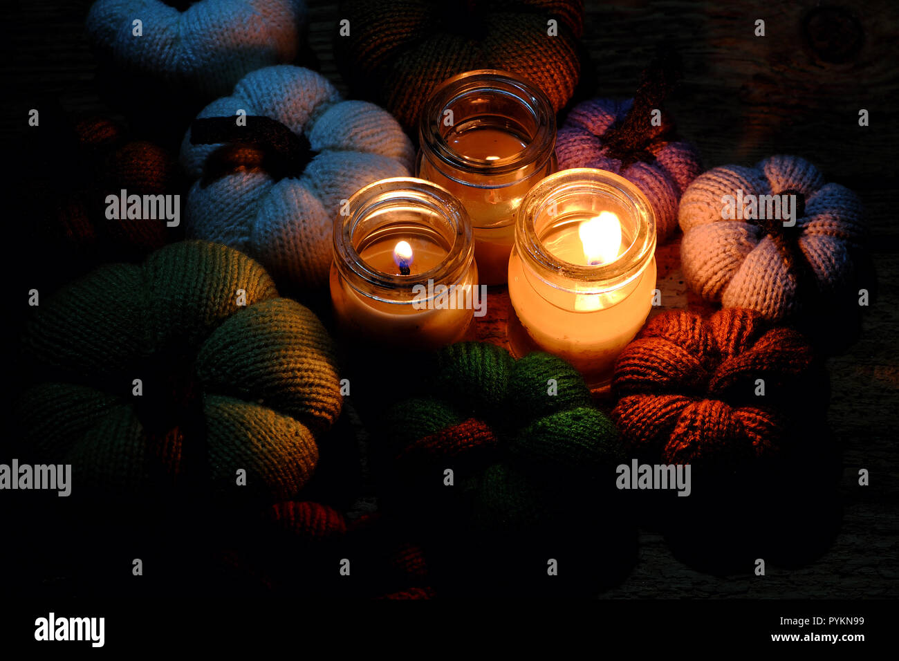 Beautiful knitted pumpkin from yarn with three candles in night, candle ...
