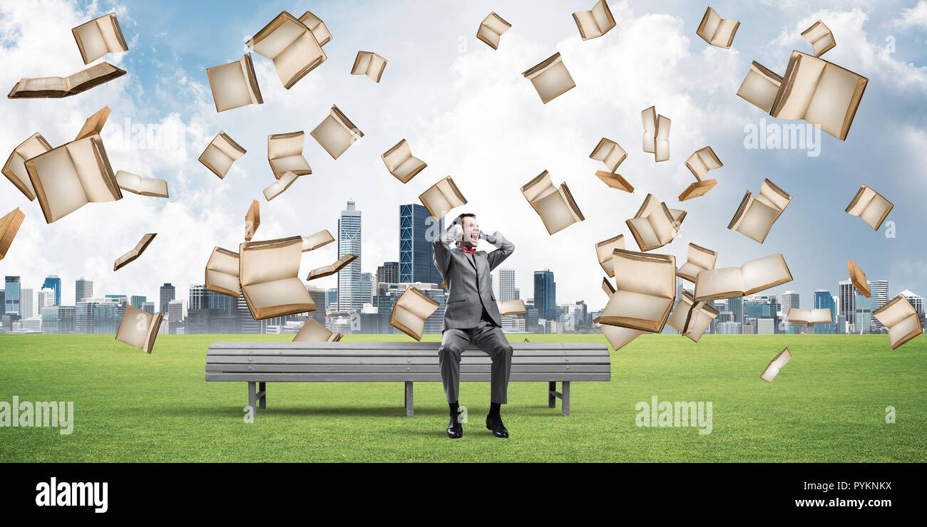 Many old books falling from above and student guy sitting on bench ...