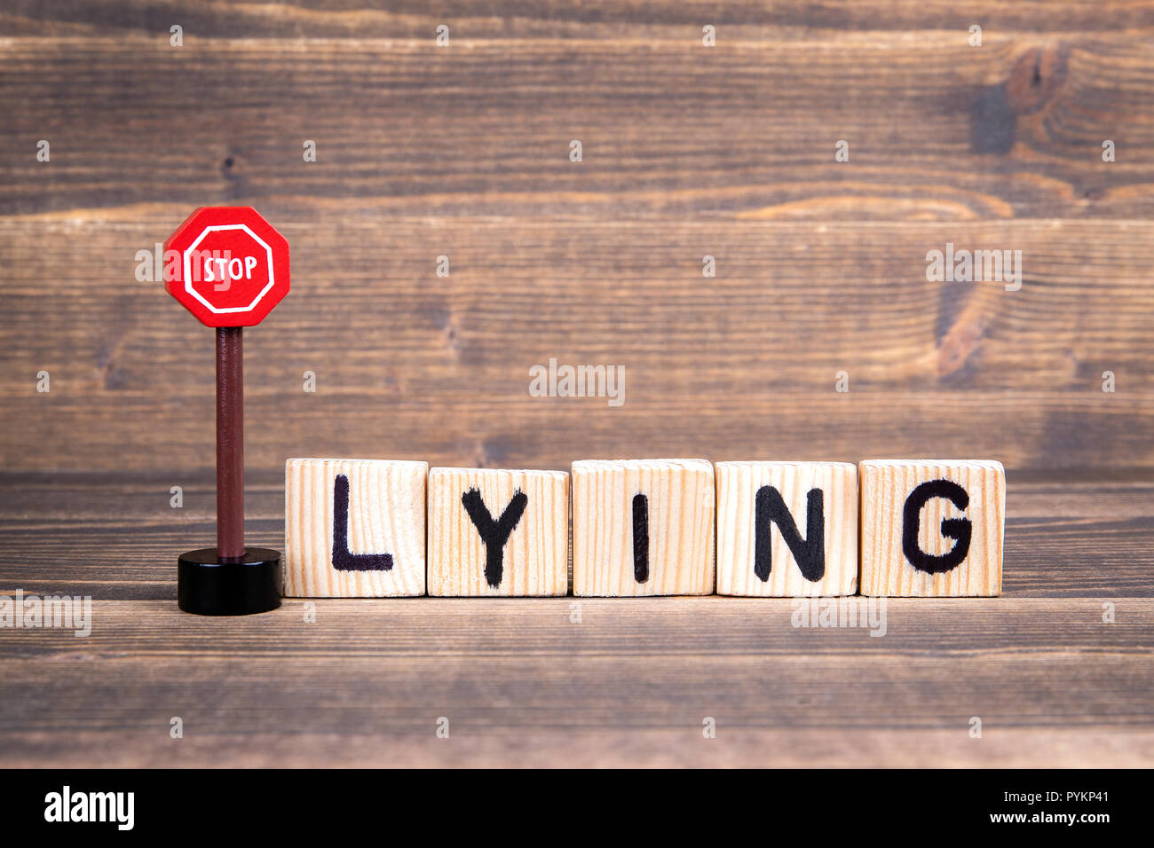 Lying concept. Wooden letters with road sign Stock Photo - Alamy