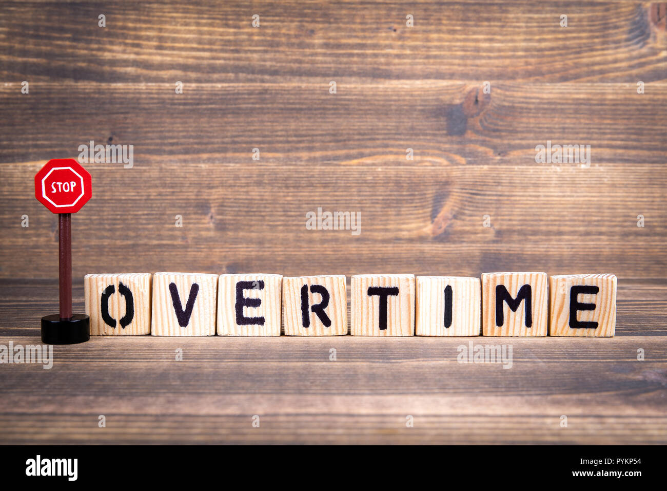Overtime concept. Wooden letters with road sign Stock Photo - Alamy