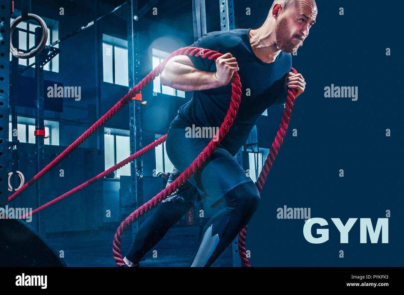 Men with battle rope battle ropes exercise in the fitness gym. CrossFit ...