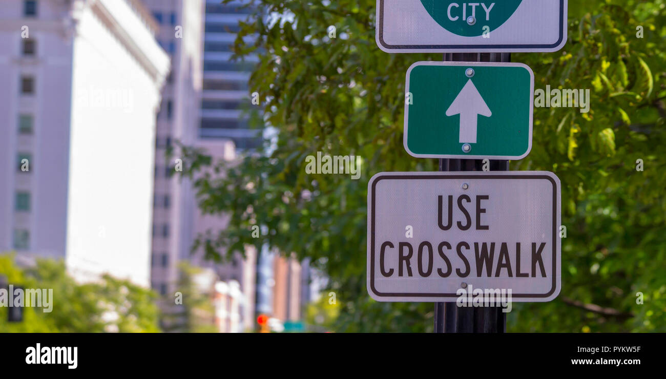 Use crosswalk and arrow signs on a sunny street Stock Photo - Alamy