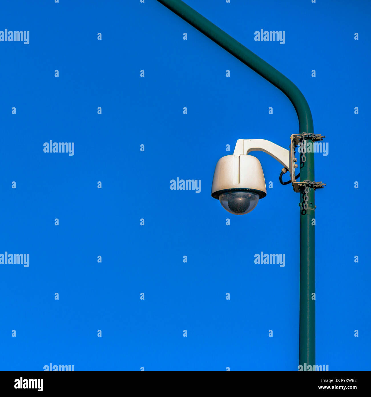 White dome security camera on a green pole Stock Photo - Alamy
