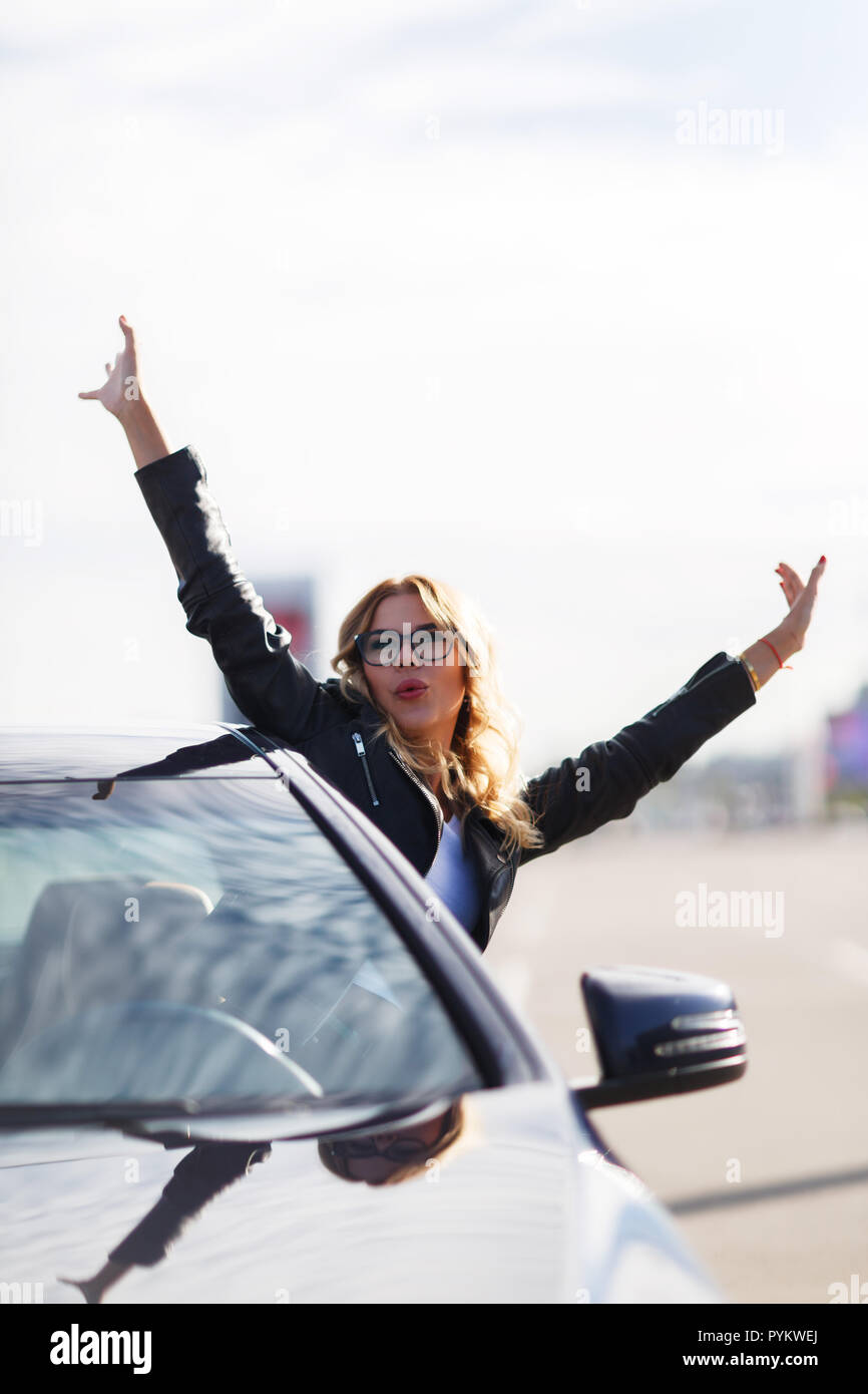 Image of young woman with glasses popping out of black car Stock Photo ...
