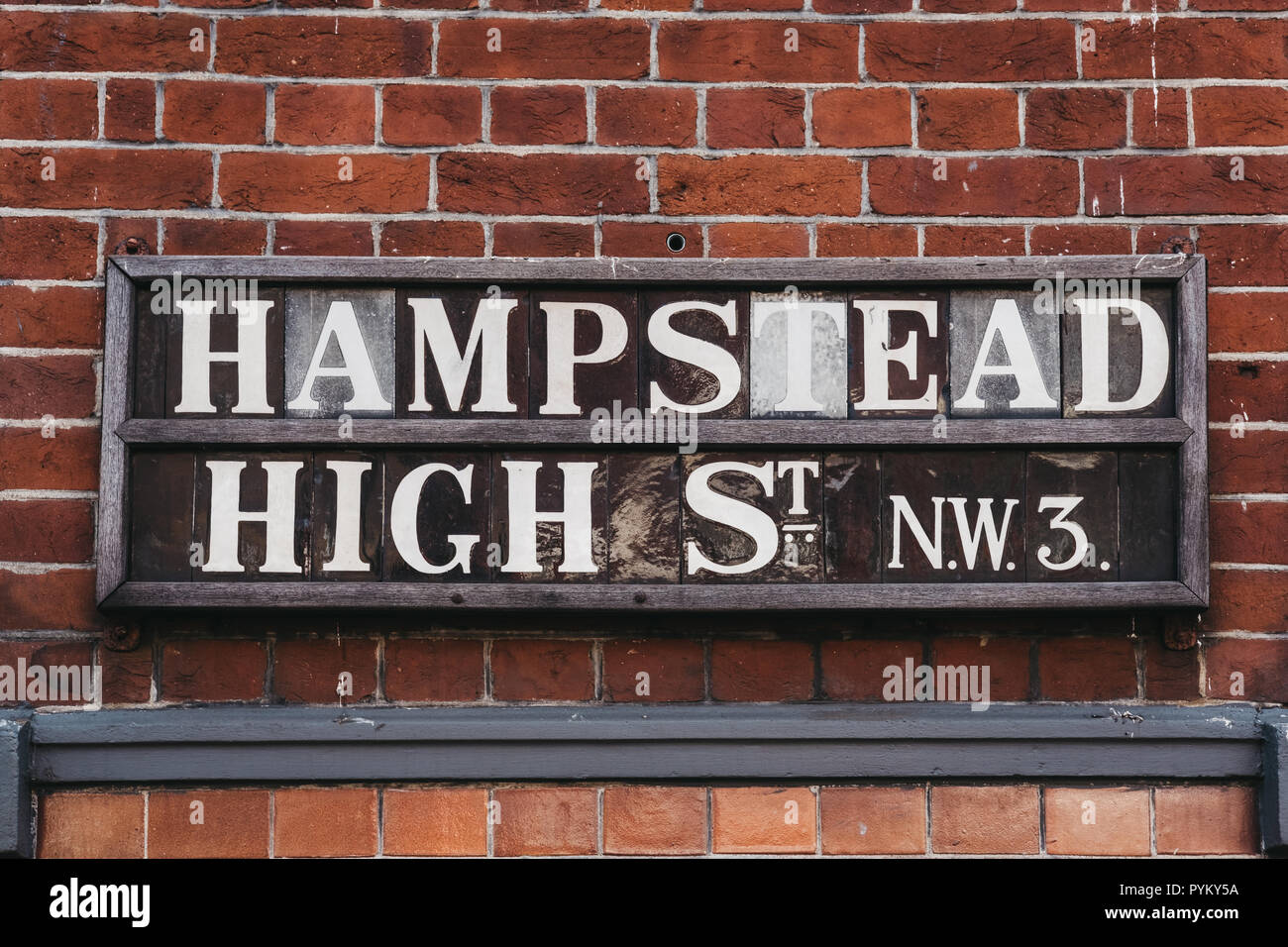 Street name sign on a side of the building on Hampstead High Street ...