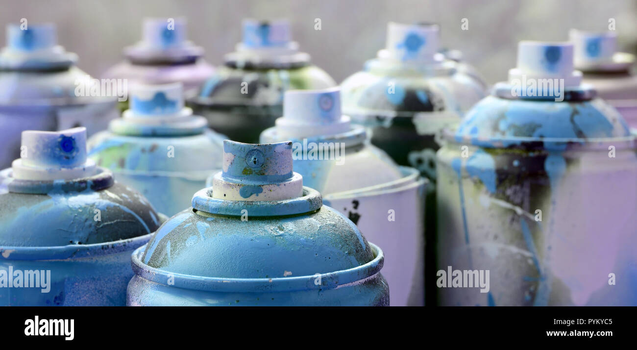 A lot of dirty and used aerosol cans of bright blue paint. Macro ...