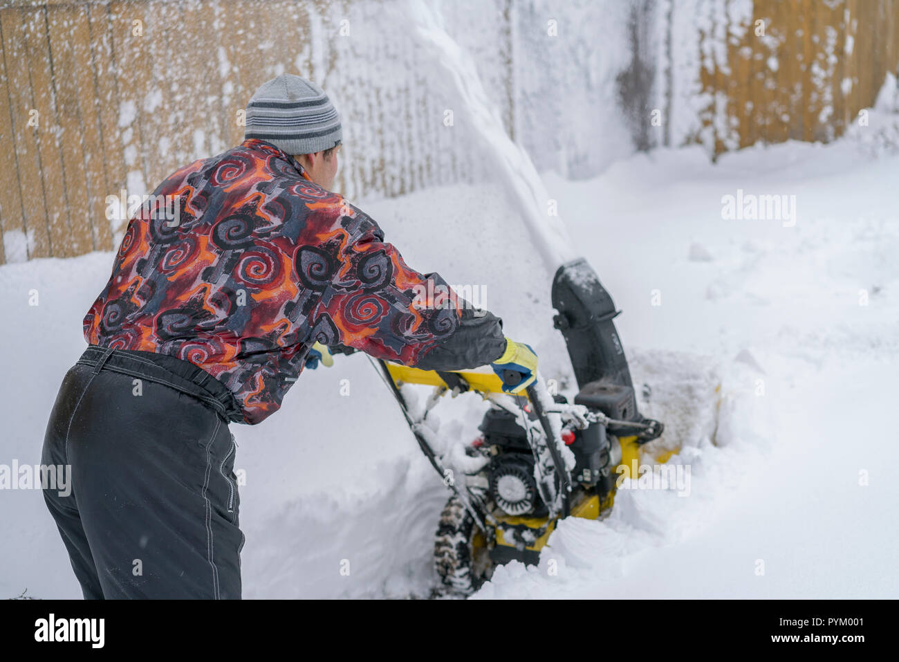A man cleans snow from sidewalks with snowblower Stock Photo - Alamy