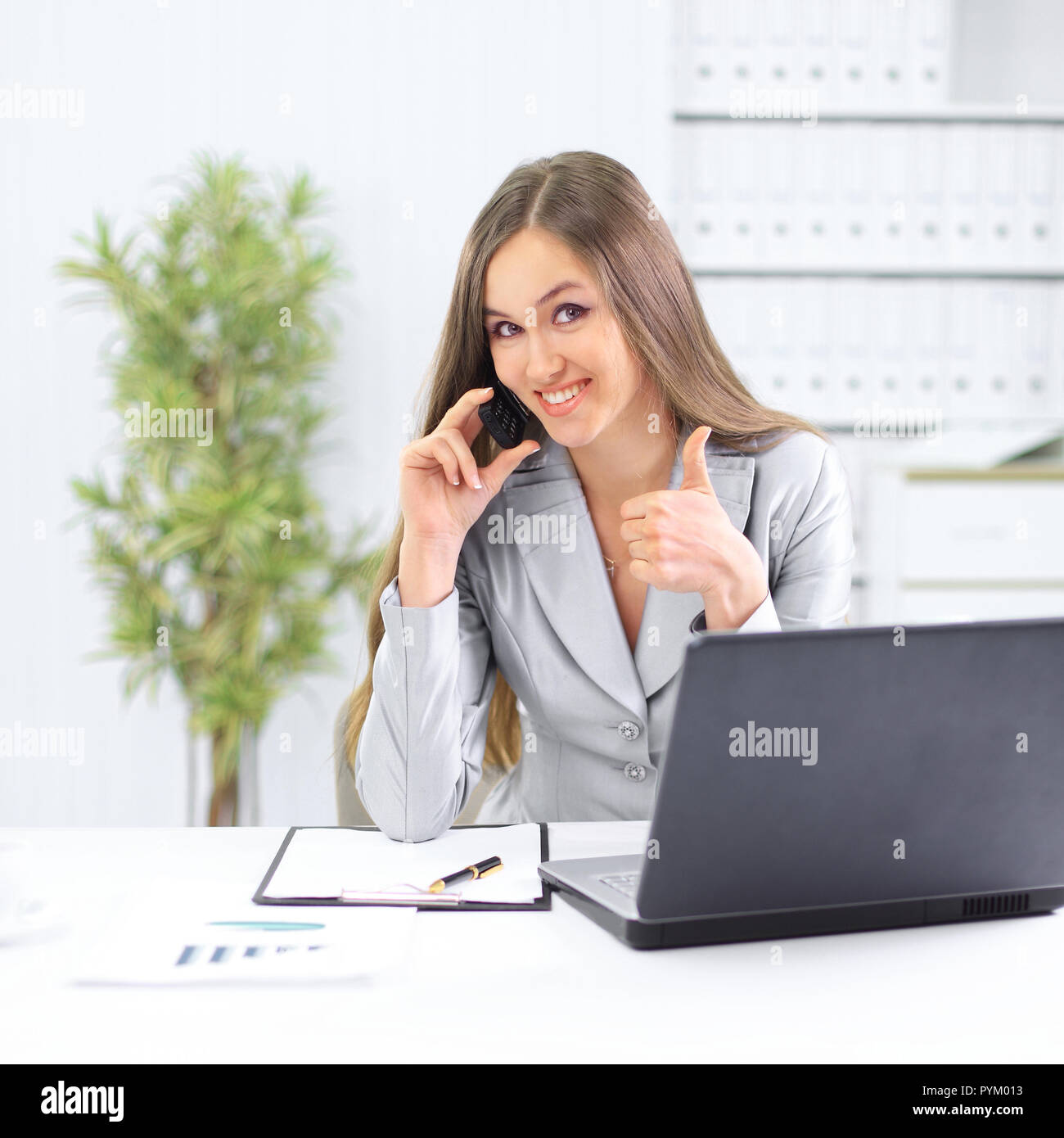 female assistant talking on the phone sitting behind a Desk Stock Photo ...