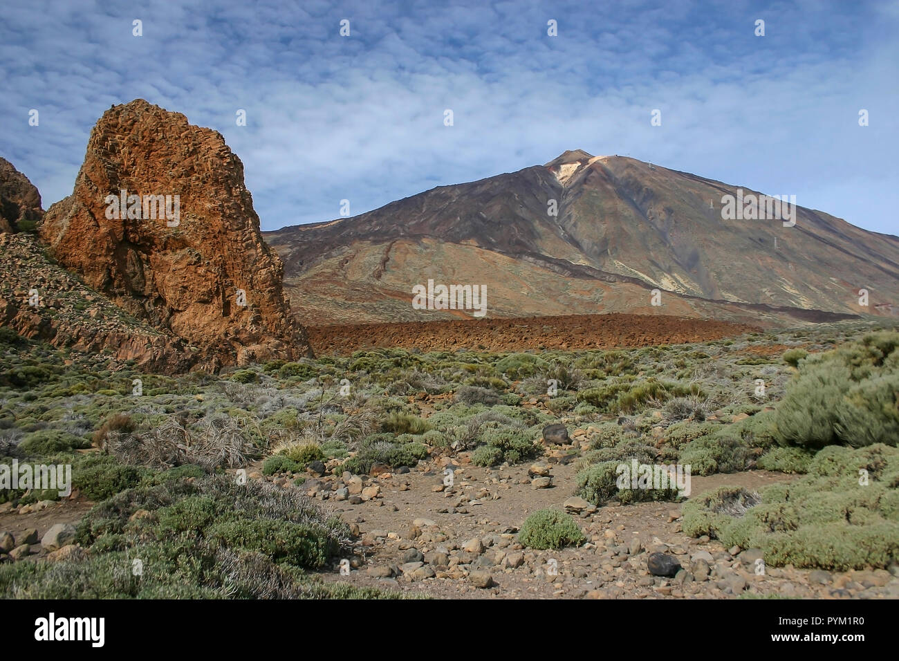 brown lava soil with volcano el teide in background with crater mound ...