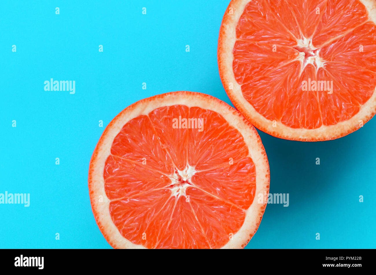Top view of a several grapefruit slices on bright background in blue ...