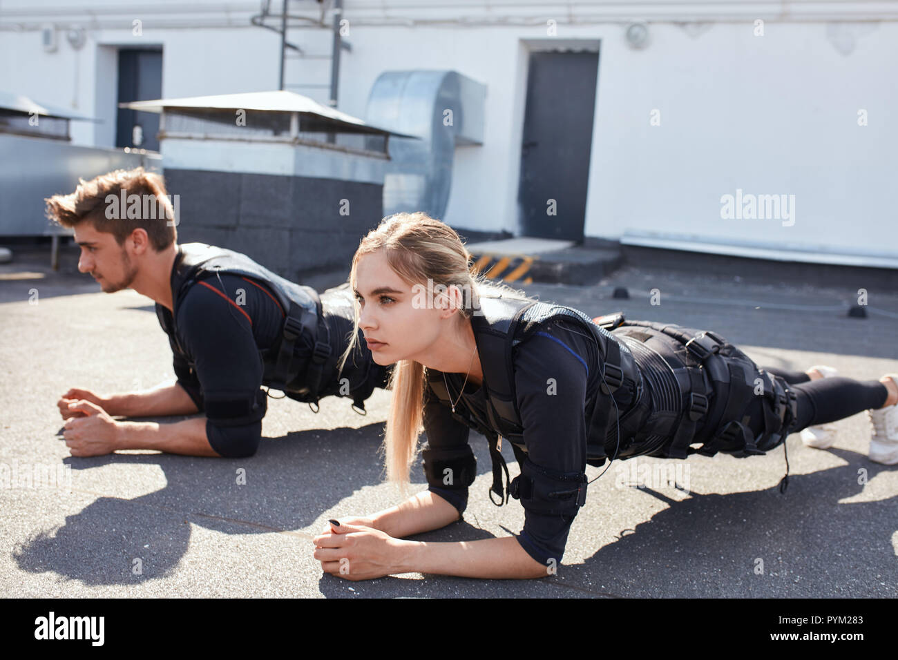Sportsmen wearing ems costume training on the floor Stock Photo - Alamy