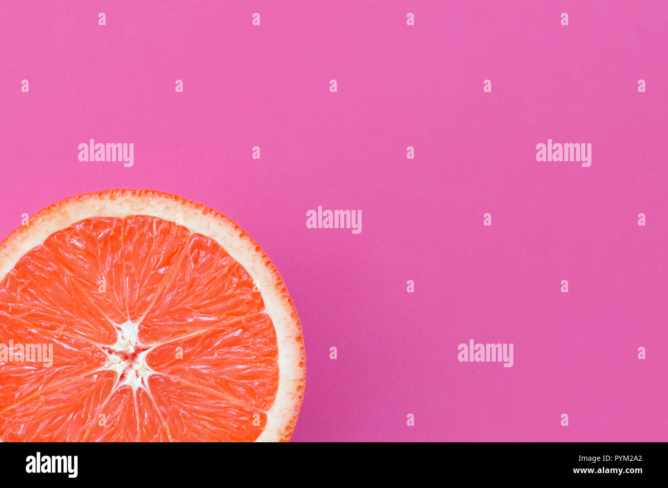 Top view of an one grapefruit slice on bright background in purple ...