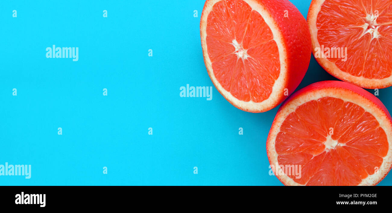Top view of a several grapefruit slices on bright background in blue ...