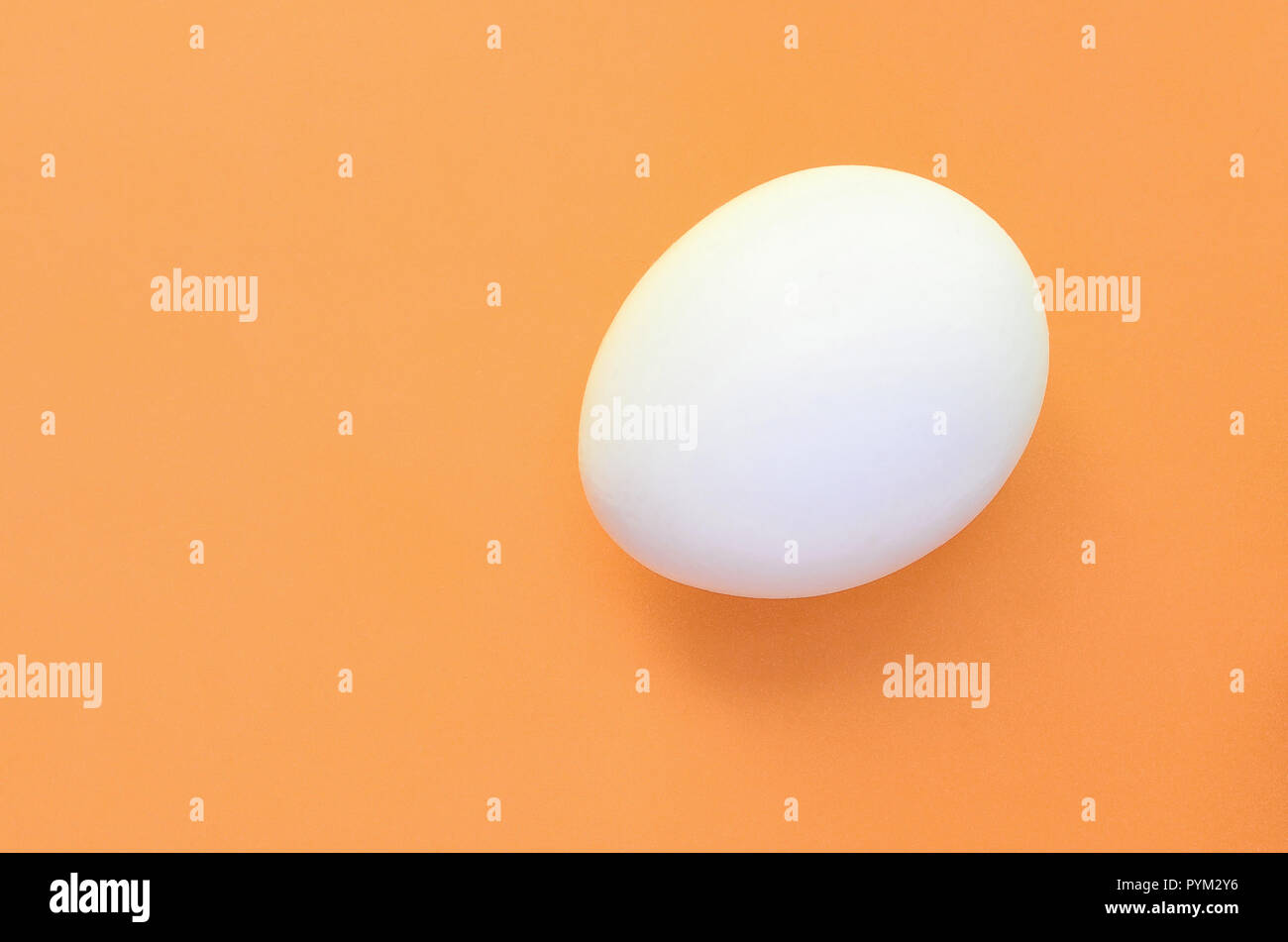 One white easter egg on a bright orange background Stock Photo - Alamy