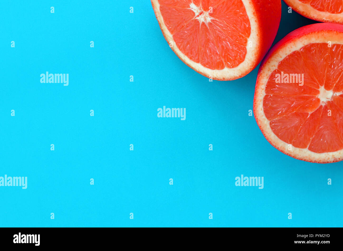 Top view of a several grapefruit slices on bright background in blue ...