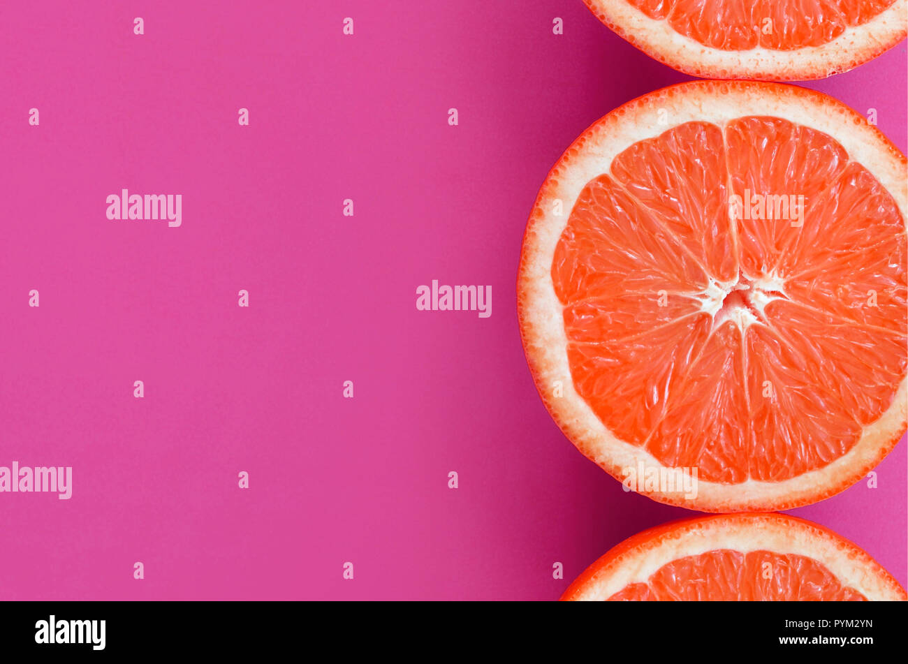 Top view of a several grapefruit slices on bright background in purple ...