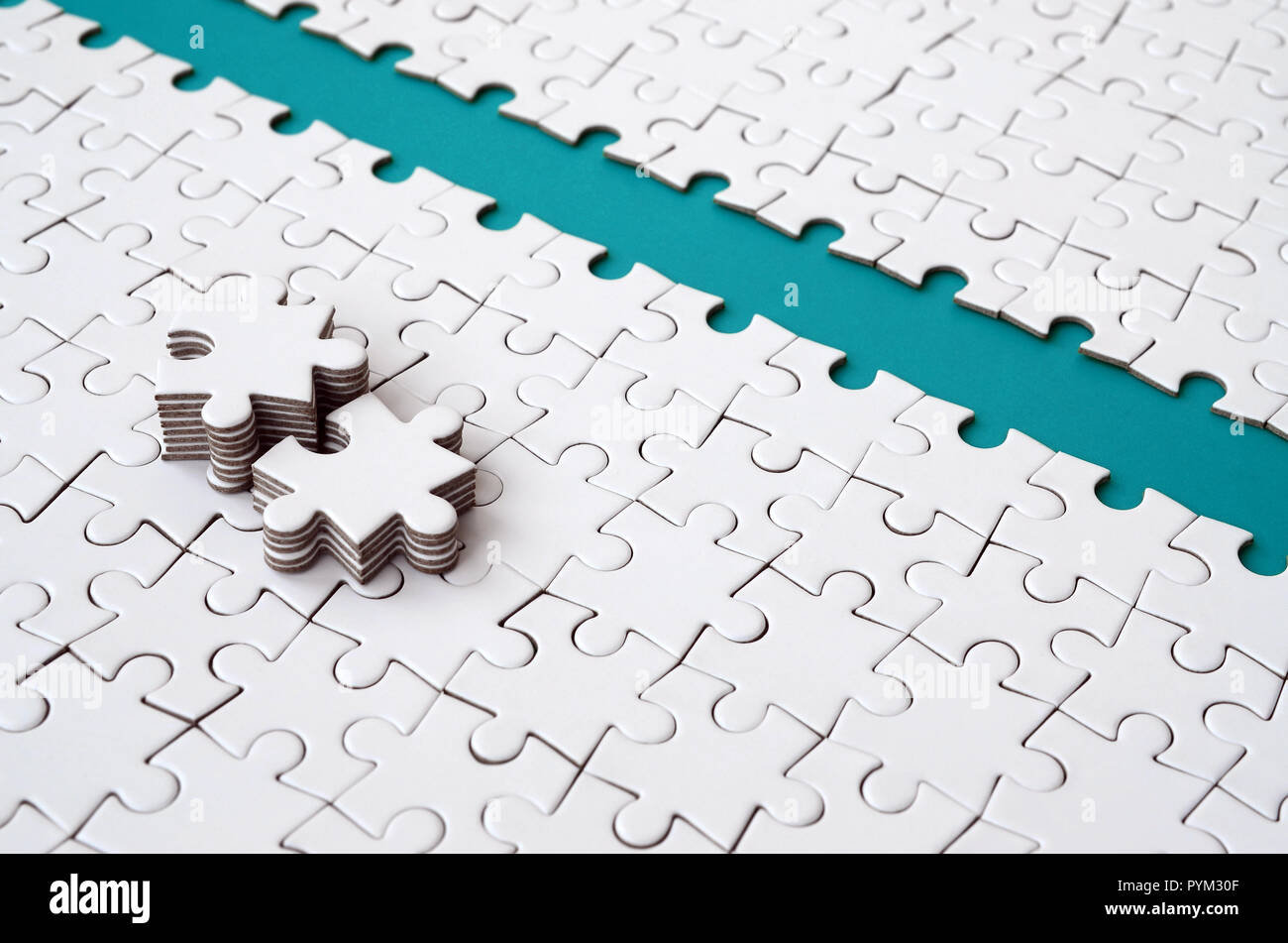 The blue path is laid on the platform of a white folded jigsaw puzzle ...