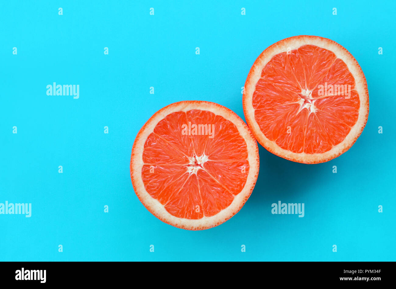 Top view of a several grapefruit slices on bright background in blue ...