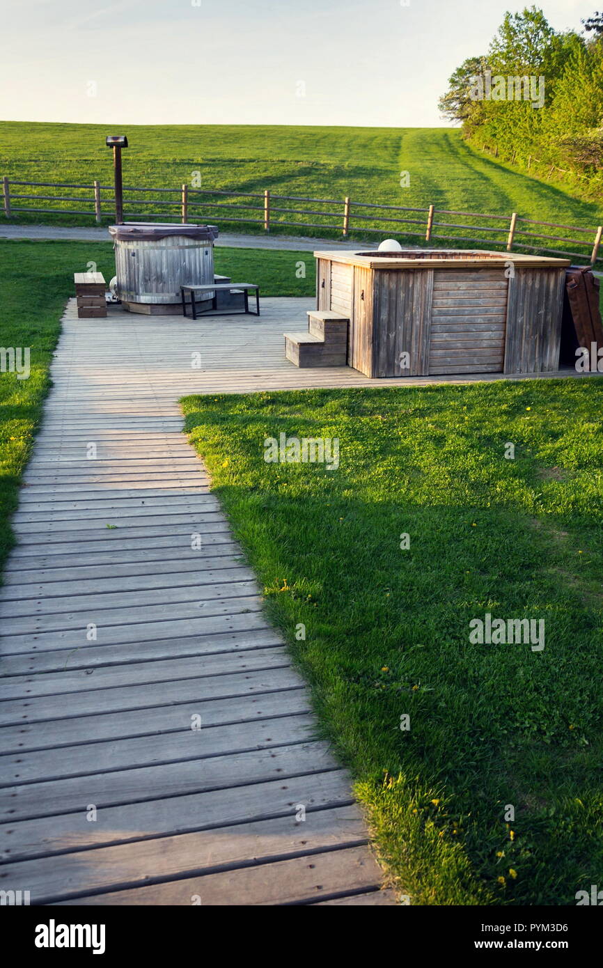 Wooden whirlpool and hot tub during sunset in beautiful summer rural ...